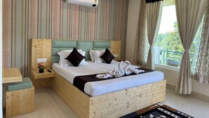 Quarto de hotel com cama de madeira, ventoinha no teto, janela com cortinas e parede listrada.