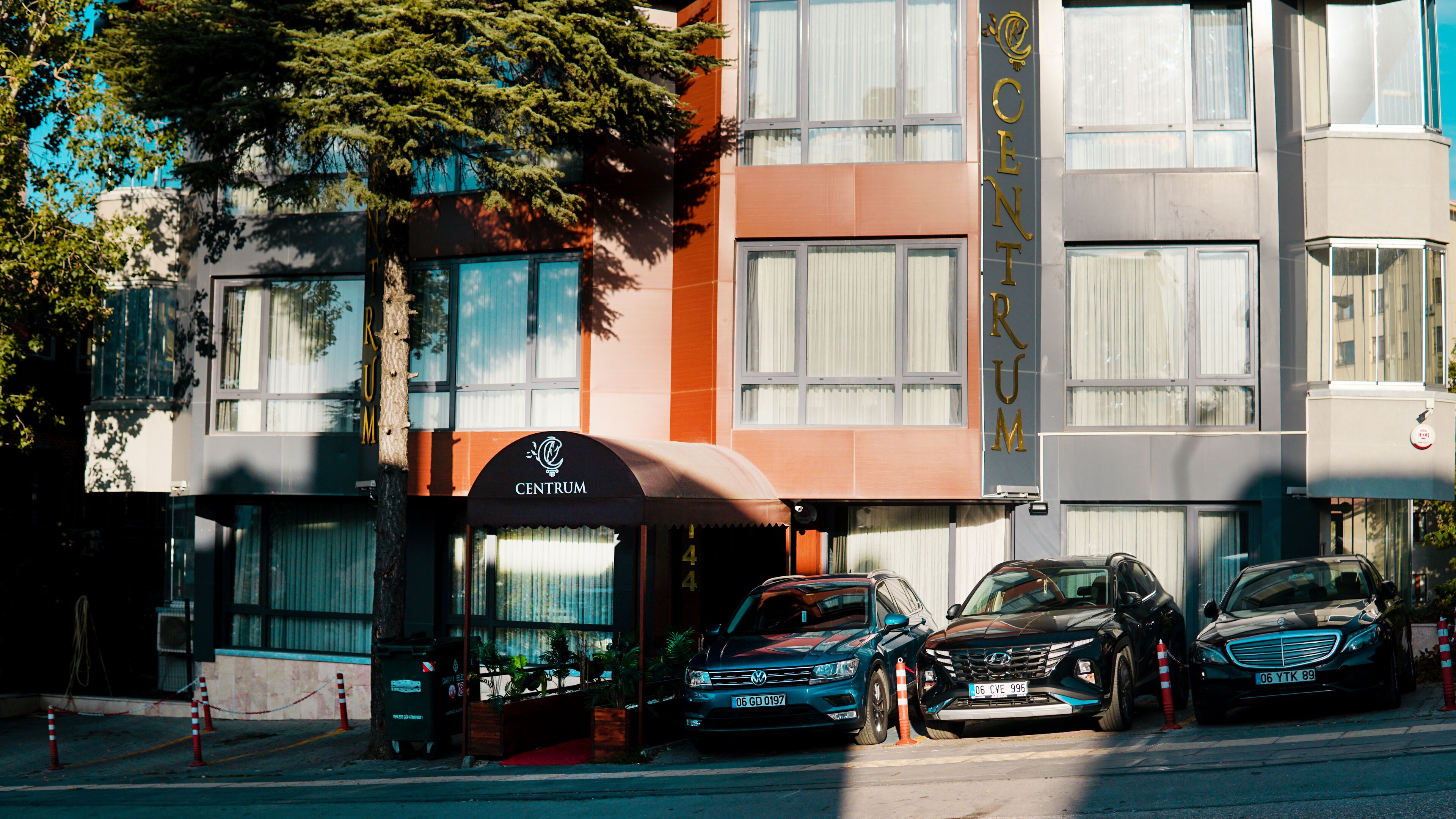 Um edifício com uma placa indicando 'CENTRUM' e uma fileira de carros estacionados.