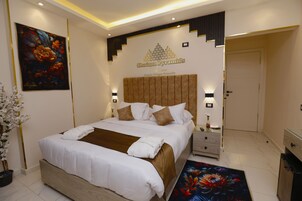 Quarto de hotel moderno com uma cama grande, um detalhe decorativo na parede e uma placa com a inscrição "Horizon Pyramids".