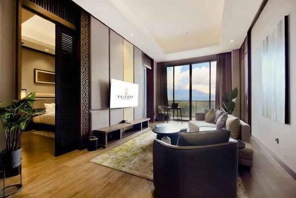 Quarto de hotel moderno com uma cama grande, TV, sofá e varanda com vista.