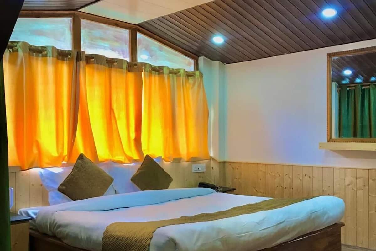 Quarto com cama de madeira, cortinas laranja e teto de madeira.