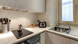 Cozinha moderna com forno embutido, pia e janela acima da pia.