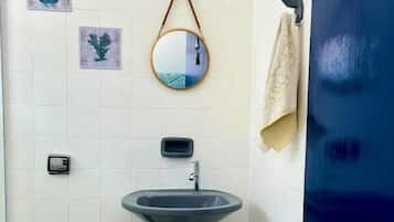 Um banheiro com pia de pedestal, vaso sanitário e porta azul.
