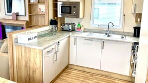 Cozinha compacta com micro-ondas, torradeira e pia.