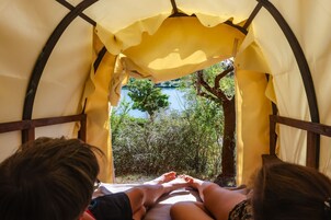 Uma tenda com vista para um lago e árvores.