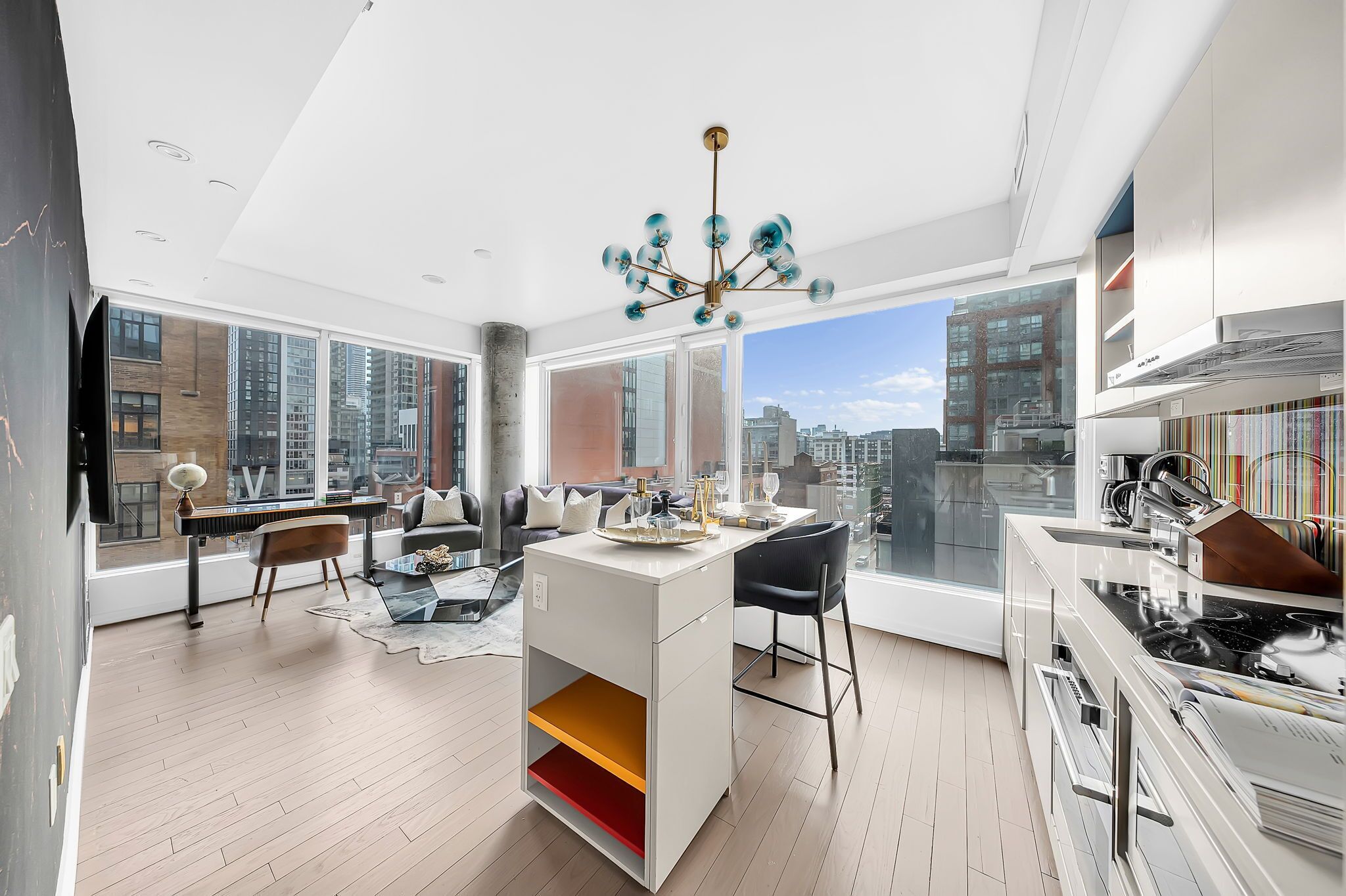 Apartamento moderno com cozinha, sala de jantar e uma grande janela com vista para a cidade.