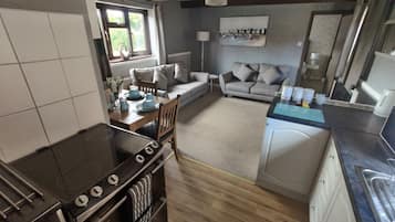 Apartamento, 2 quartos | Área de estar | TV 32 polegadas com canais a cabo, brinquedos