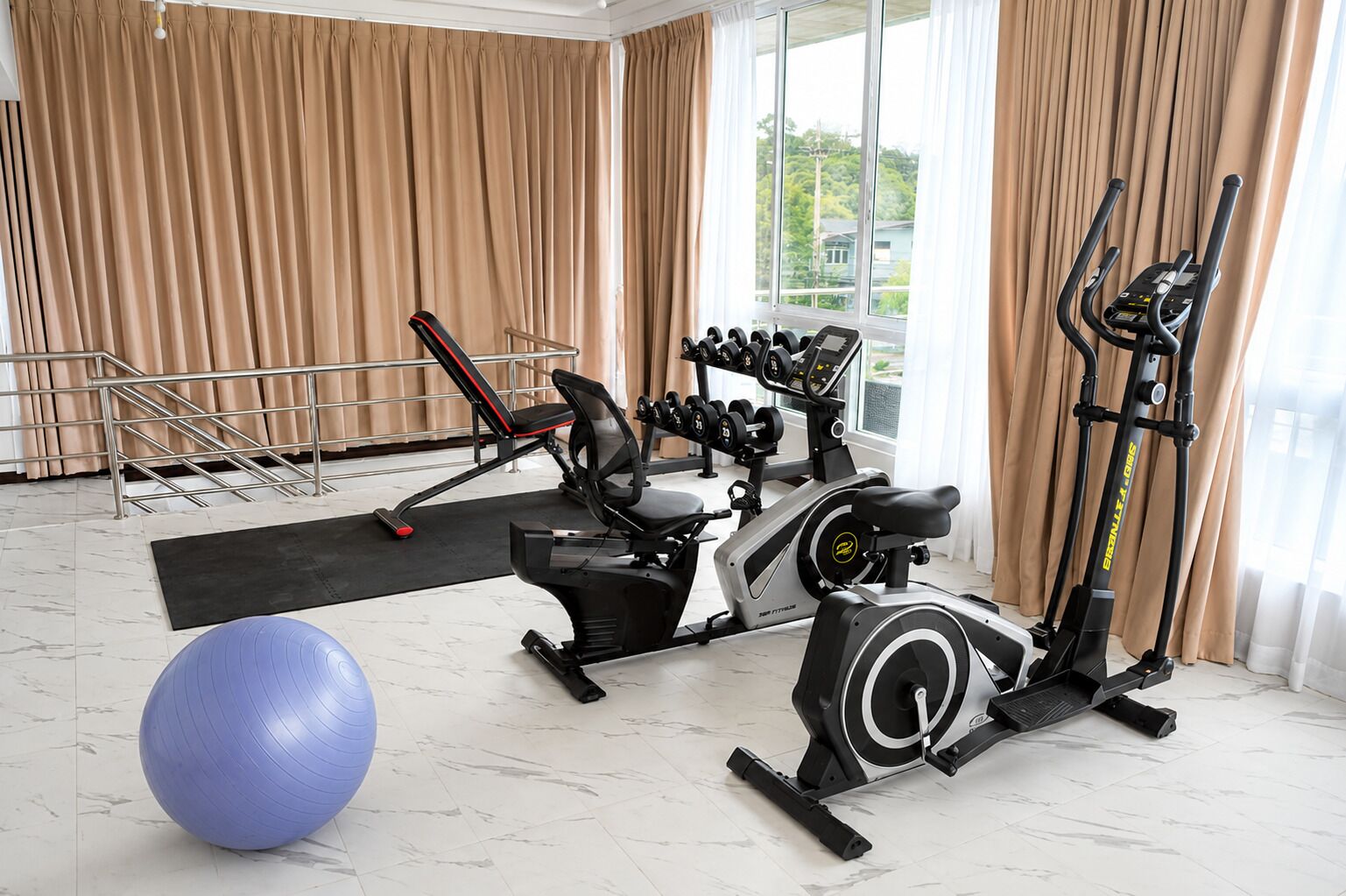 Uma academia em casa com equipamentos de exercícios, um tapete de yoga e uma bola de ginástica grande.