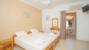 Quarto com duas camas, uma mesa de cabeceira de madeira, um espelho e aparelho de ar condicionado.