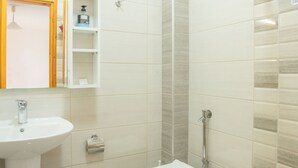 Uma casa de banho moderna com lavatório, sanita e chuveiro.