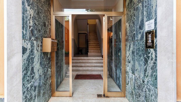 Hall de entrada com piso de mármore e escadaria para o segundo andar.