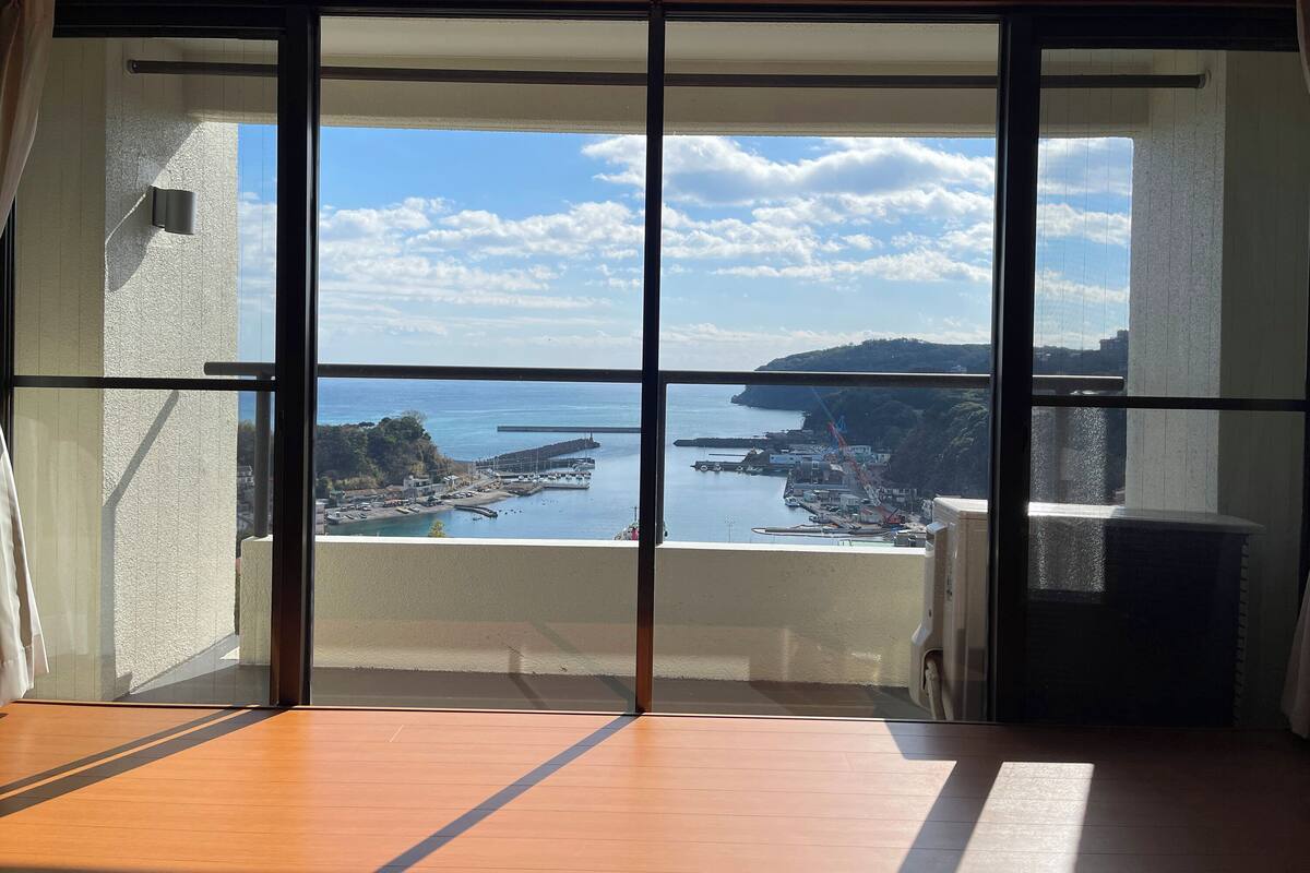 Quarto com uma grande porta de correr de vidro que dá para a vista da costa.