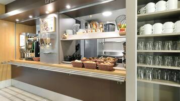 Uma área de buffet com diversos alimentos, cestas e copos.