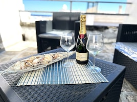 Uma garrafa de champanhe Moët & Chandon sobre uma mesa, com dois copos e uma travessa de frutos do mar.