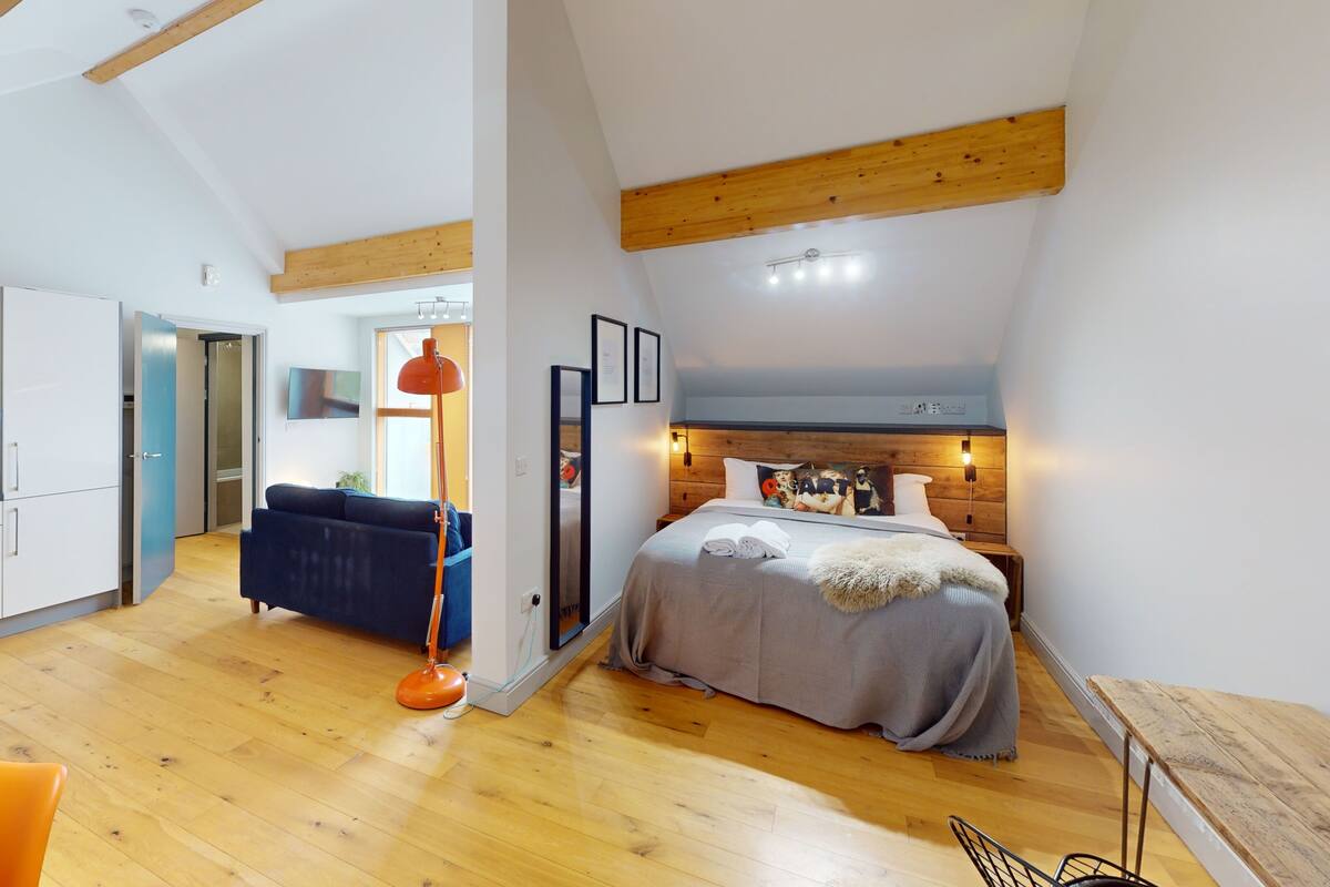 Um loft moderno com cozinha, sala de estar e quarto.
