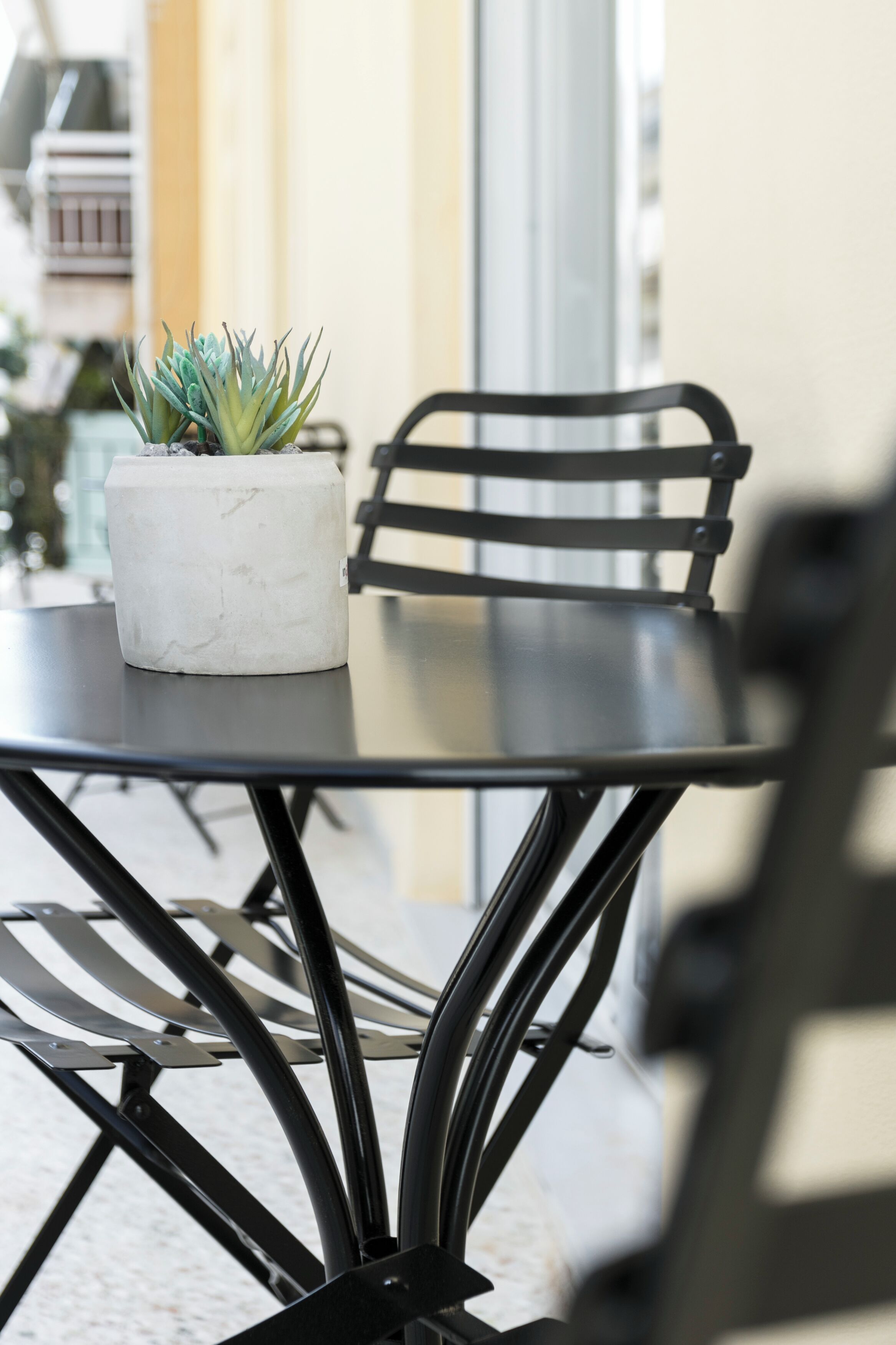 Uma mesa com uma planta em vaso e uma cadeira.