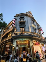 Um edifício histórico com elementos arquitetônicos chineses tradicionais, incluindo varandas ornamentadas e esculturas detalhadas.