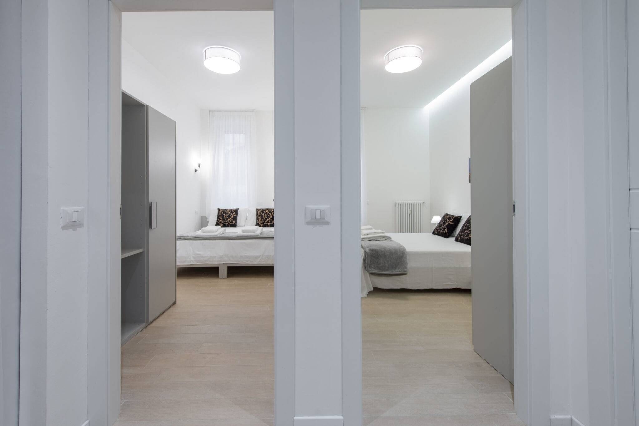Quarto moderno com cama, mesas de cabeceira e radiador.