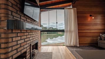 Cabana de Madeira Deluxe, banheira de hidromassagem, junto ao lago | Sala | Lareira