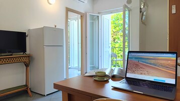 Apartamento, vista parcial para o mar | Sala de estar | Televisor