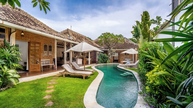 Um quintal com piscina, cadeiras de descanso e um espaço coberto de varanda.