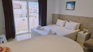 Quarto de hotel com cama, mesa de cabeceira, cadeira e vista para o exterior.