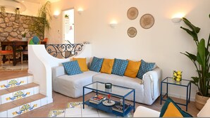 Sala de estar com sofá, mesa de centro e escada.