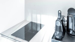 Uma cozinha moderna com forno embutido, micro-ondas e máquina de café.