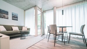 Uma sala de estar moderna com sofá, mesa de centro e área de jantar com cadeiras e mesa.