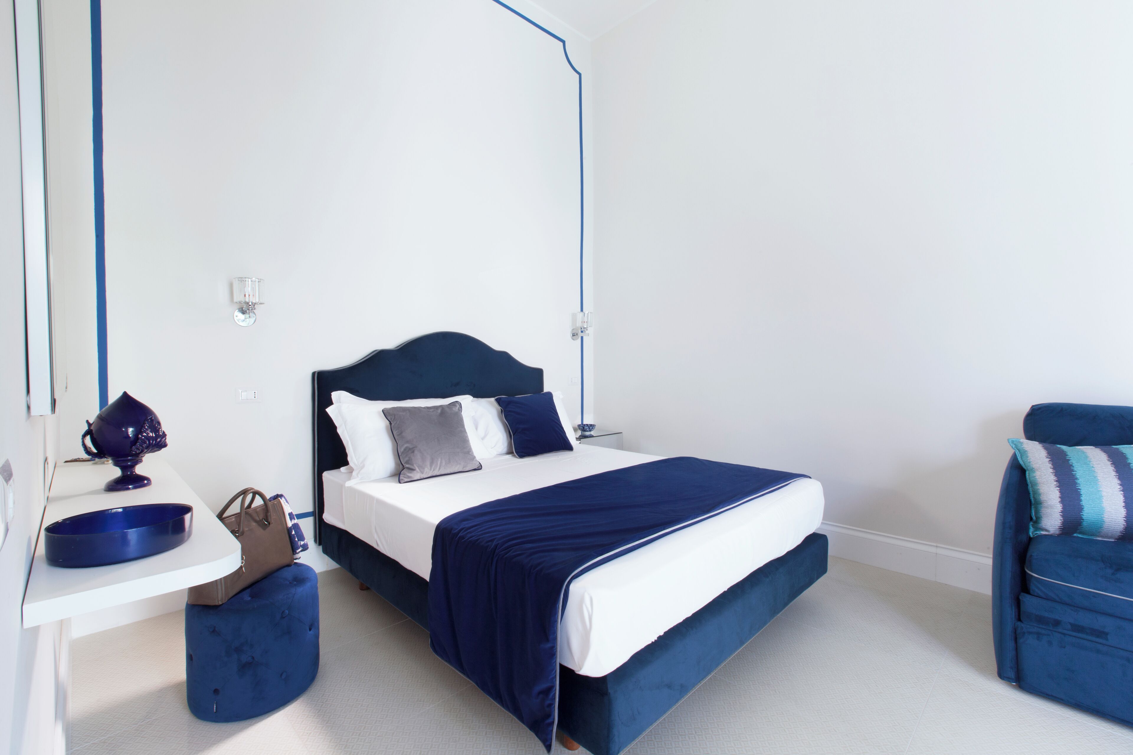 Quarto moderno com cama, mesa de cabeceira e uma cadeira.