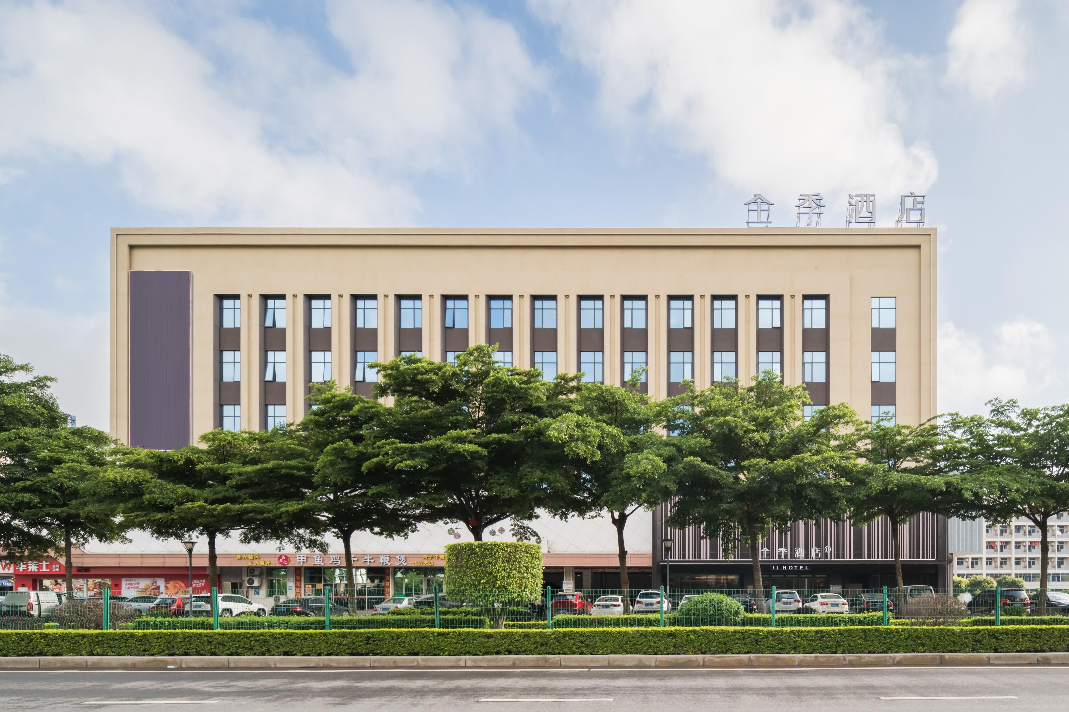 Um edifício moderno com fachada plana, várias janelas e uma placa indicando que é um hotel.