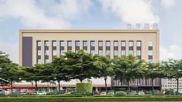 Um edifício moderno com fachada plana, várias janelas e uma placa indicando que é um hotel.