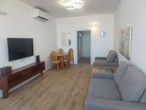 Apartamento conforto, sacada, vista para a praia | Área de estar | TV de tela plana