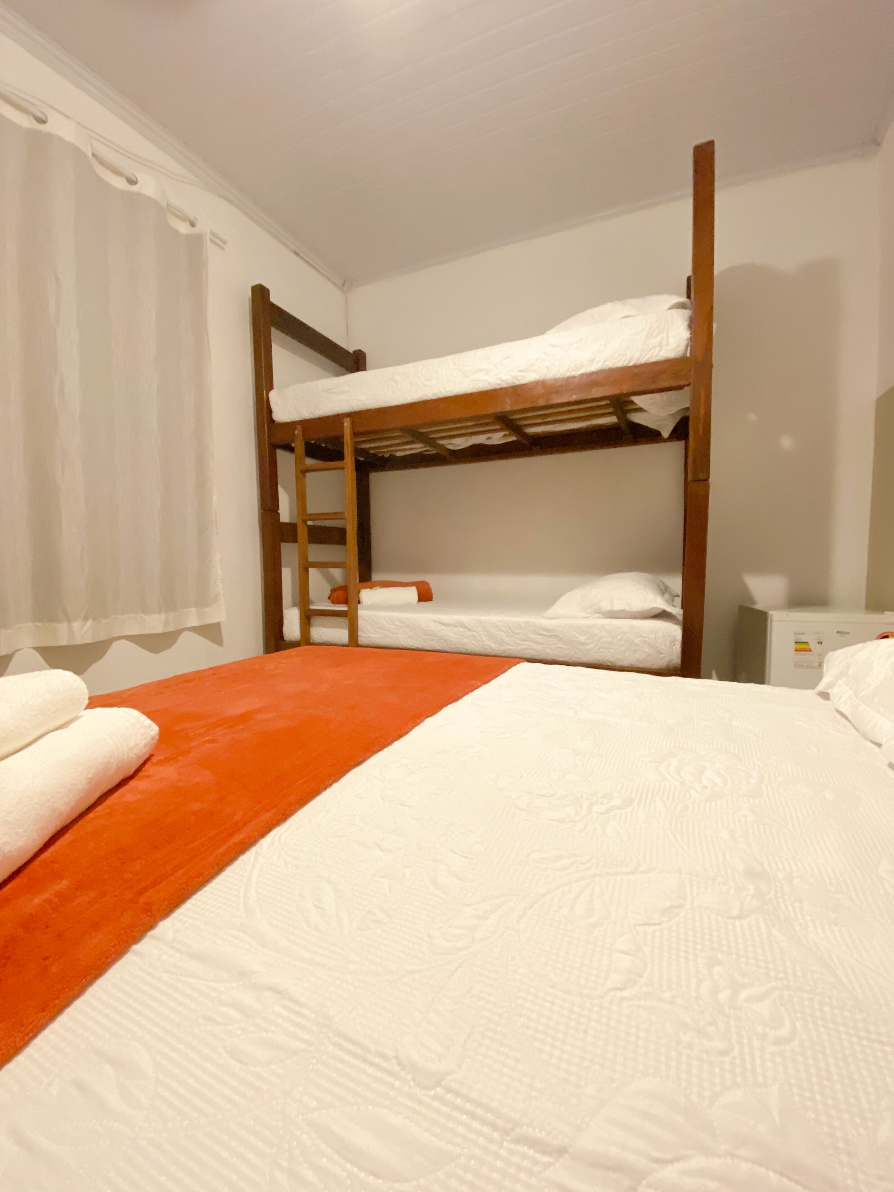 Quarto com beliche, escrivaninha e cadeira.