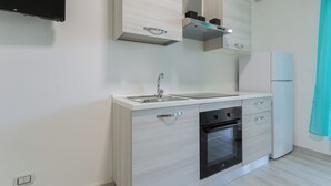 Uma cozinha moderna com forno embutido, pia e geladeira.