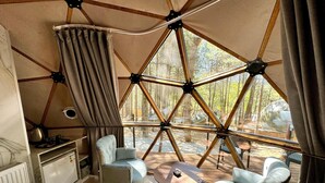 Um quarto acolhedor com uma janela grande, móveis de madeira e uma mesa redonda.