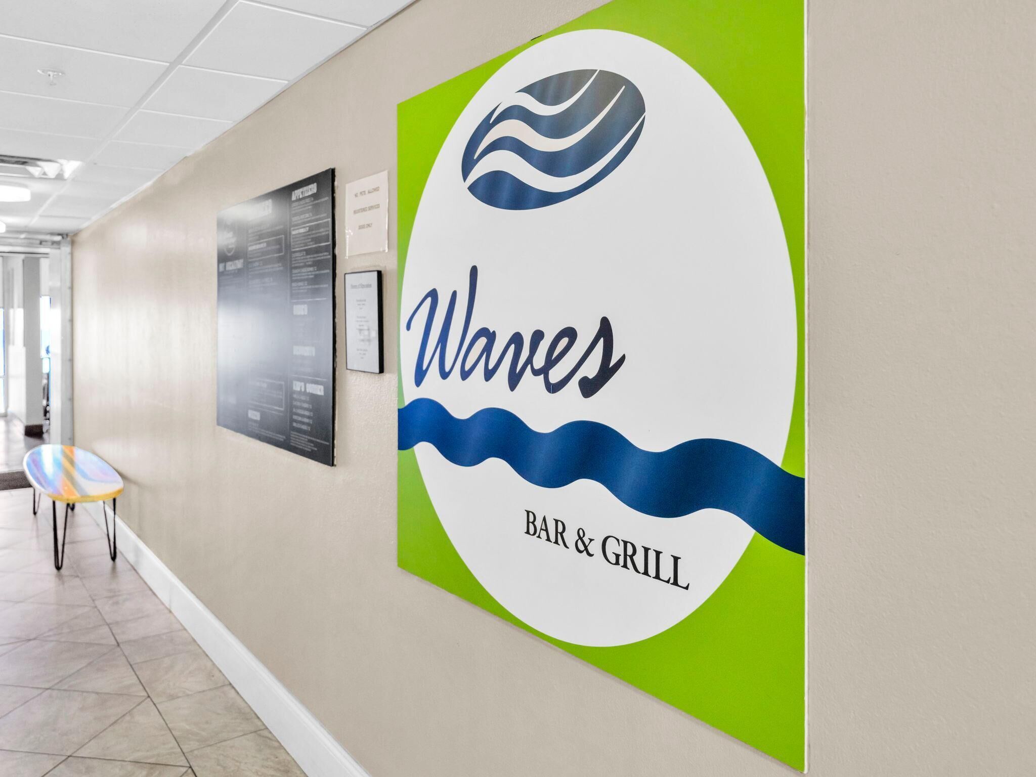 Corredor com placa indicando Waves Bar & Grill, exibindo um logotipo com design de onda.