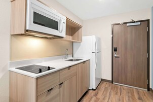 Um frigorífico/congelador grande, um micro-ondas, uma placa de cozinha 