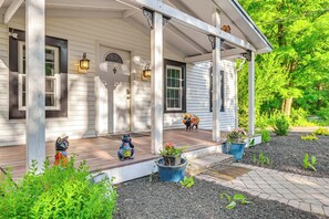 Uma casa com varanda, plantas em vasos e figuras decorativas de animais.