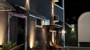 Uma casa com piscina, área de estar externa e um terraço coberto.