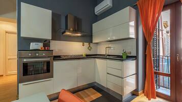 Apartamento, varanda | Cozinha privada | Um frigorífico, um forno, uma placa de cozinha