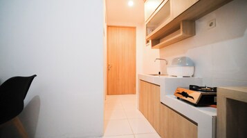 Apartamento Deluxe | Cozinha privada | Um frigorífico, uma placa de cozinha, mesas de jantar 