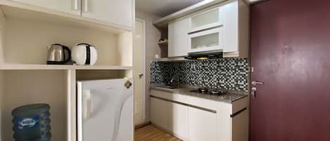 Apartamento Deluxe | Cozinha privada | Um frigorífico, uma placa de cozinha, mesas de jantar