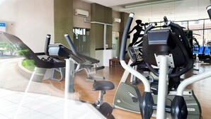 Uma academia com diversos equipamentos de exercício, incluindo esteiras e aparelhos elípticos.