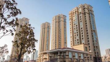 Um edifício residencial alto, com vários andares, varandas e um pátio central.
