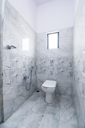 Quarto Deluxe | Casa de banho | Um polibã, um chuveiro fixo, artigos de higiene pessoal grátis 