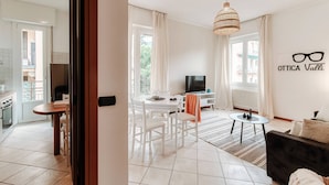 Uma sala de estar moderna com área de jantar, cozinha e vista para o exterior.