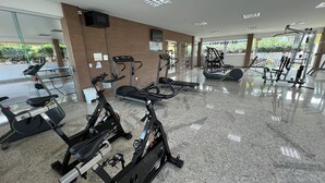 Uma academia com diversos equipamentos de ginástica, incluindo esteiras, bicicletas ergométricas e aparelhos de musculação.