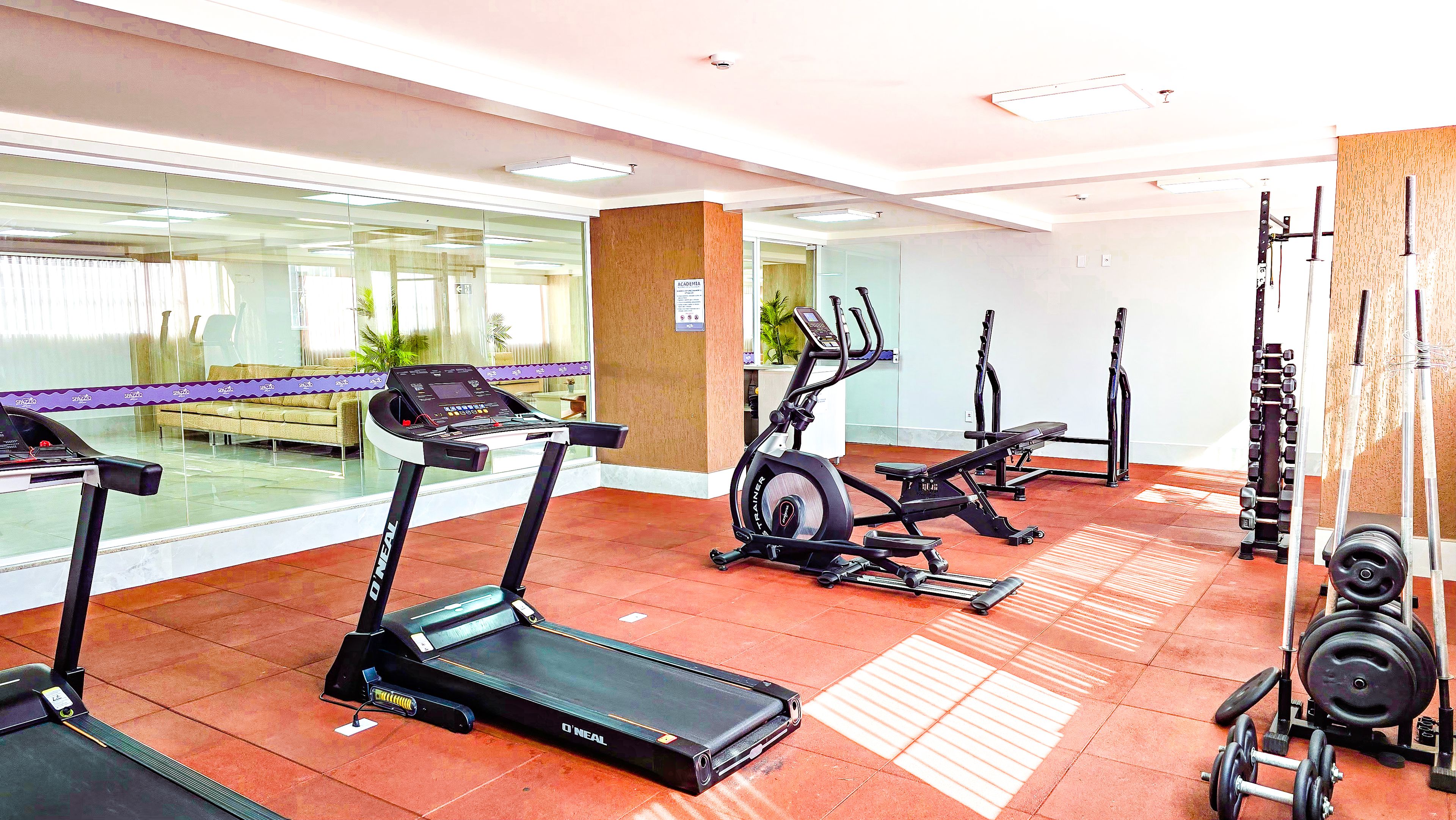 Academia equipada com esteiras, elípticos e aparelhos de musculação.
