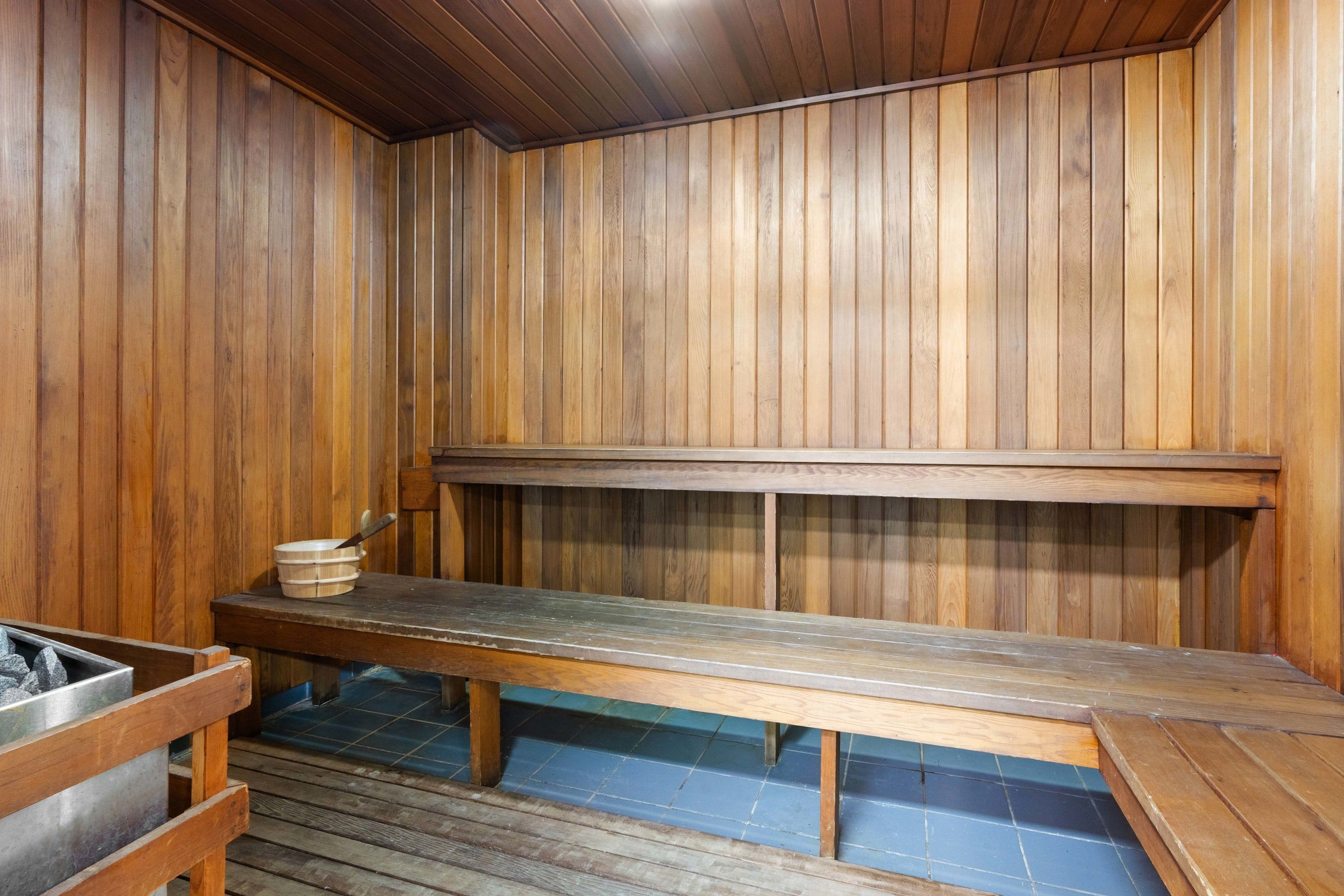 Uma sala de sauna com paredes e bancos de madeira.